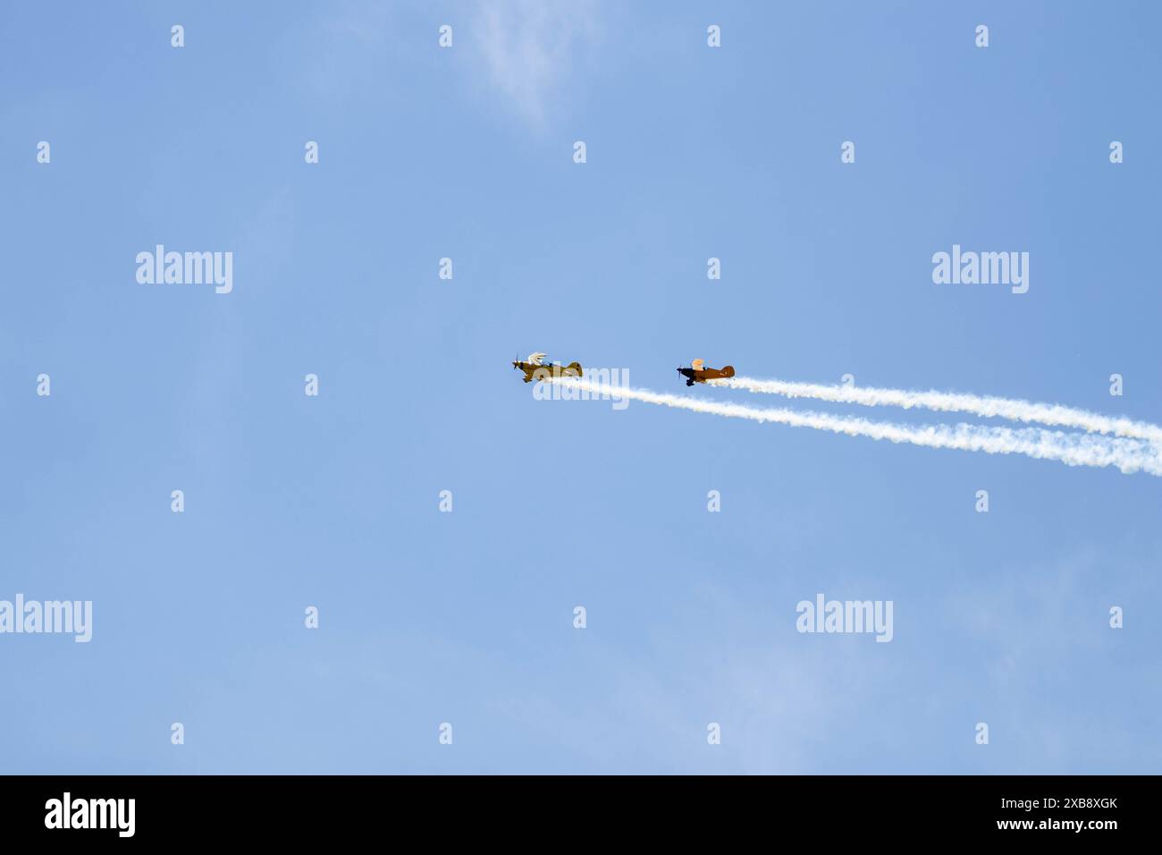 Two aircrafts flying in synchronized formation with smoke trails in the ...