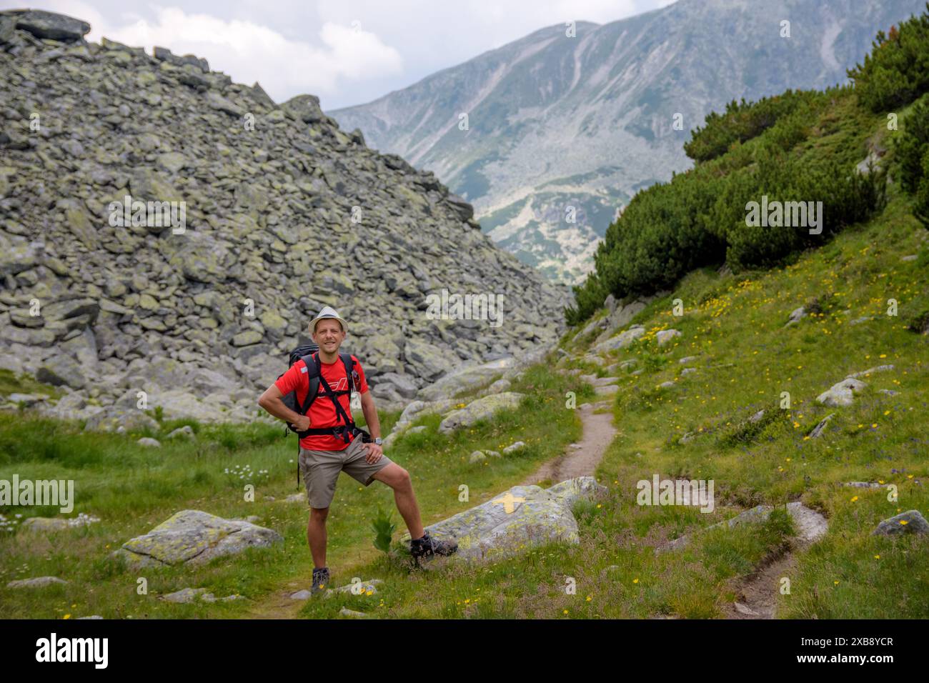 A hiker with a big backpack climbing a mountain trail Stock Photo - Alamy