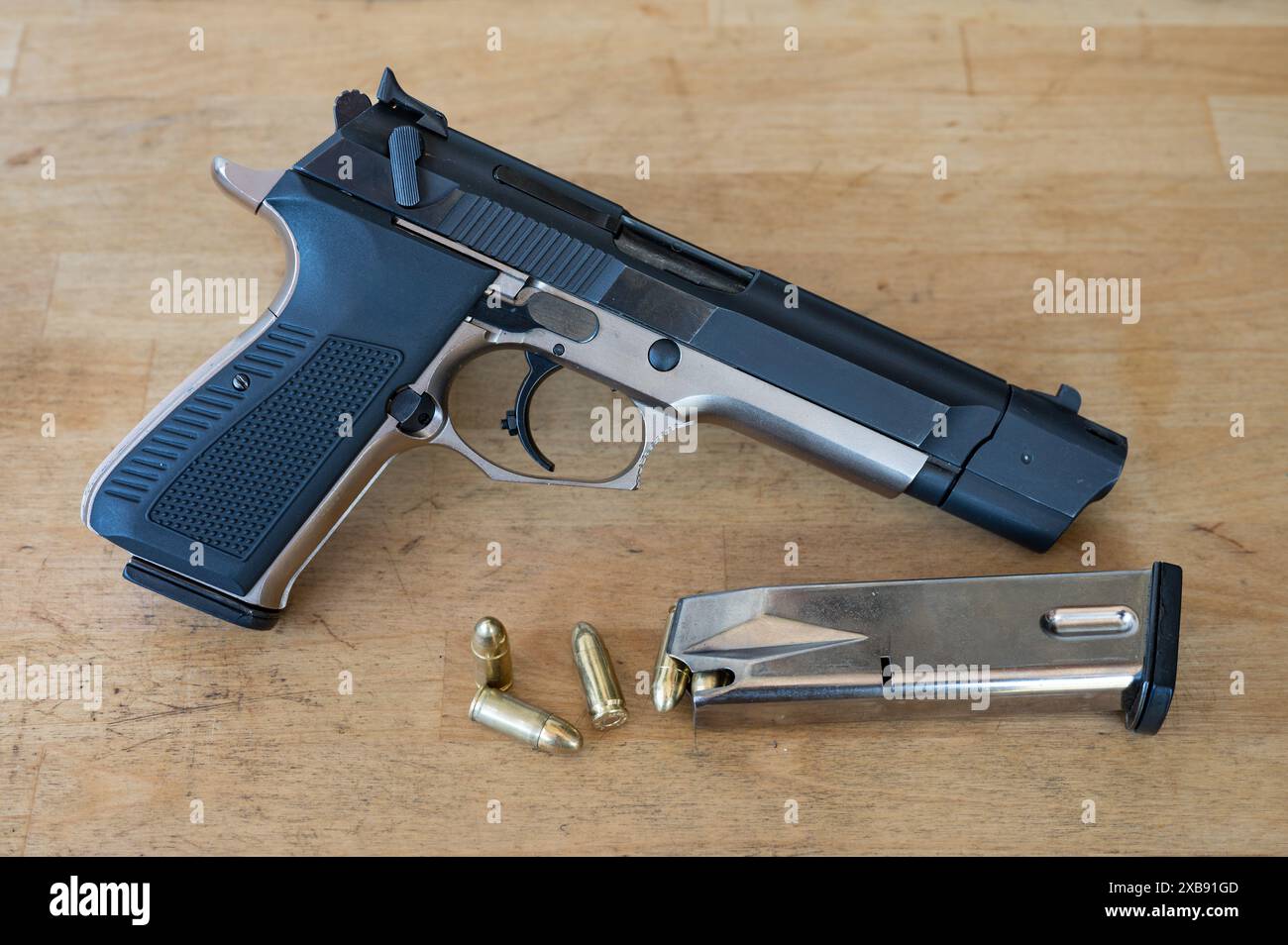 Detail of a nice 9mm police pistol next to a loaded bullet magazine and ...