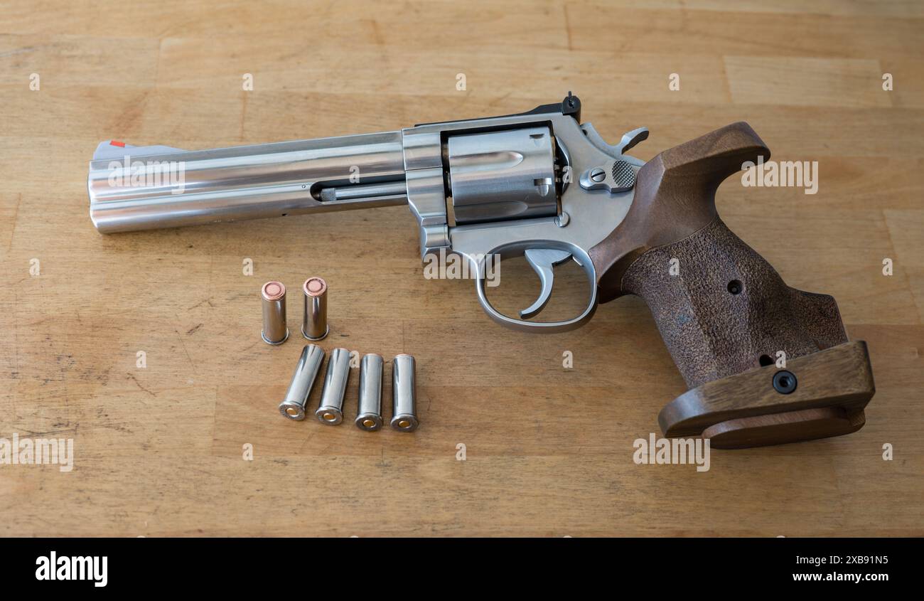 Detail of a revolver-type pistol on a wooden table Stock Photo - Alamy