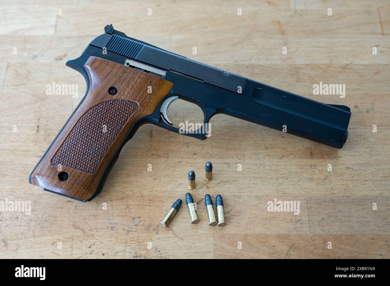 A nice classic .22 caliber pistol and a few standard bullets on the ...