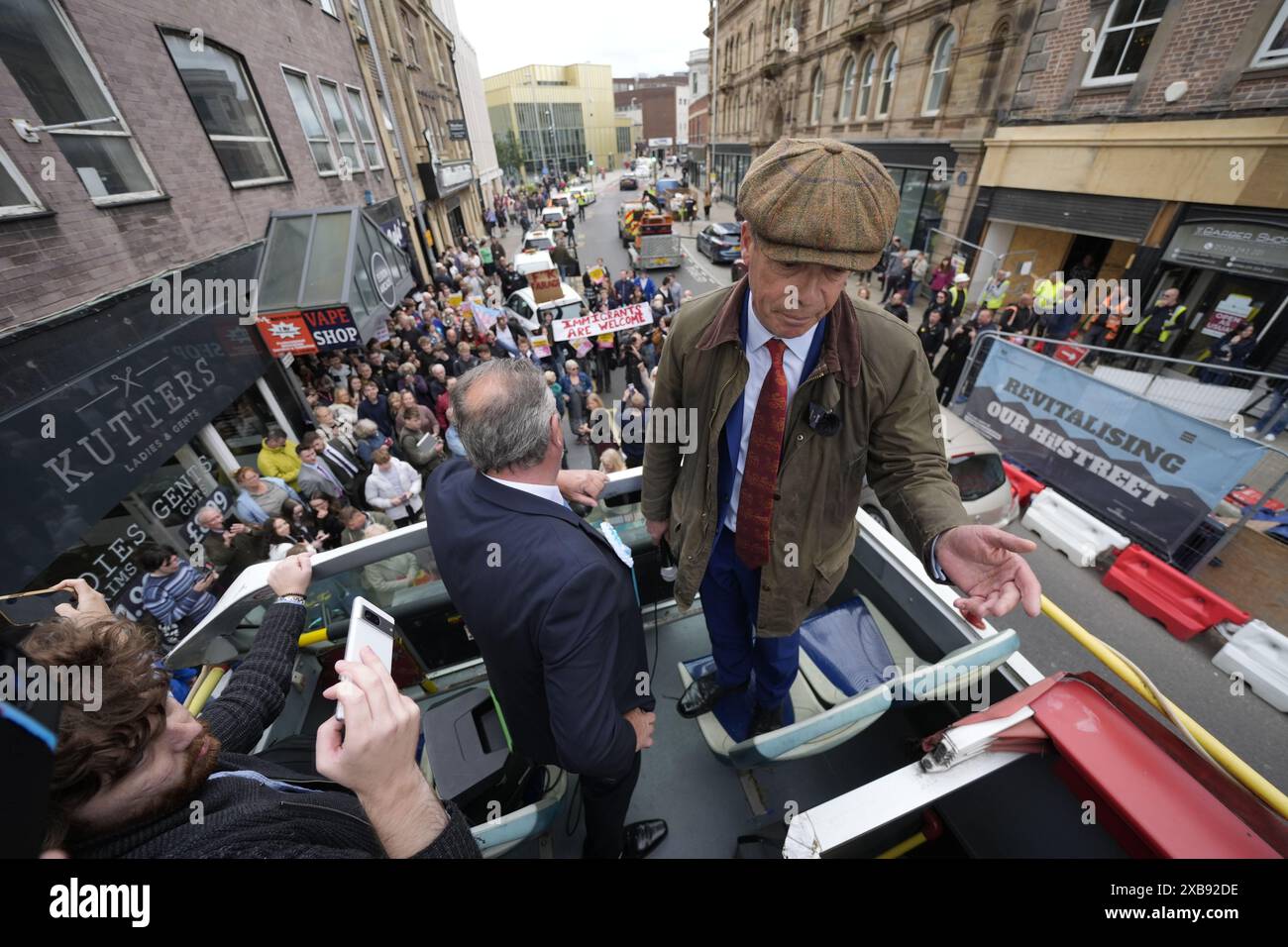 EDITORS NOTE LANGUAGE ON PLACARD Reform UK leader Nigel Farage (right ...