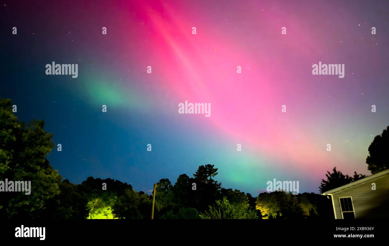 Northern lights shining above suburban trees Stock Photo - Alamy