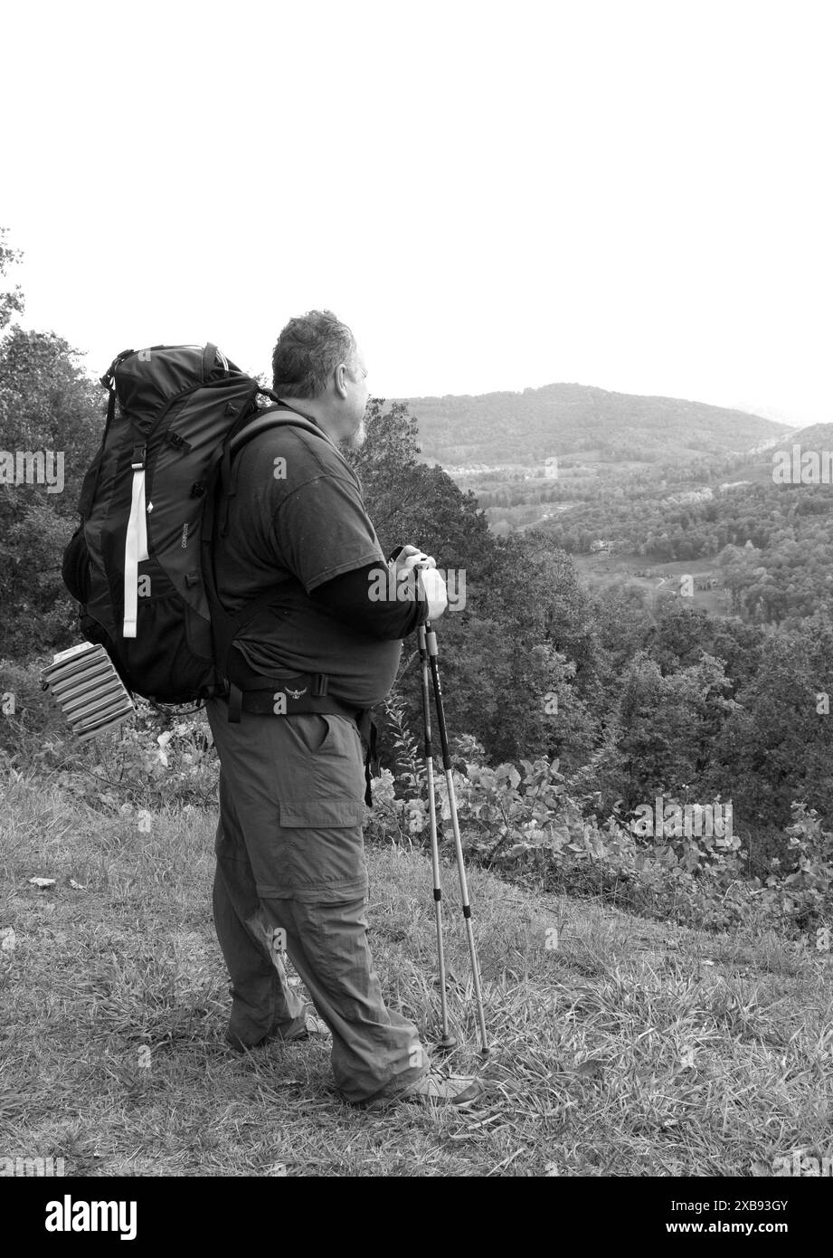 Hiker wearing backpack enjoying view of Blue Ridge Mountains at Walnut ...