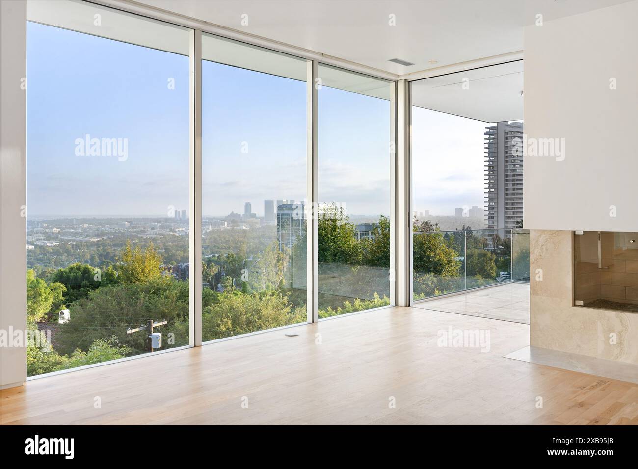 A Spacious living room with hardwood floors and full-height windows ...