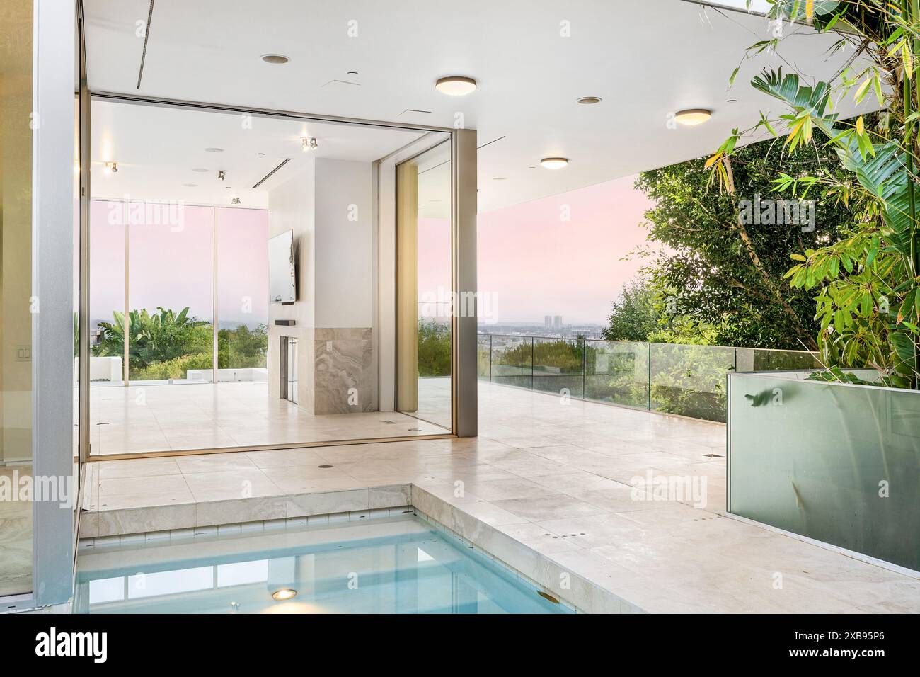 A pool beside glass doors leading to a patio Stock Photo - Alamy