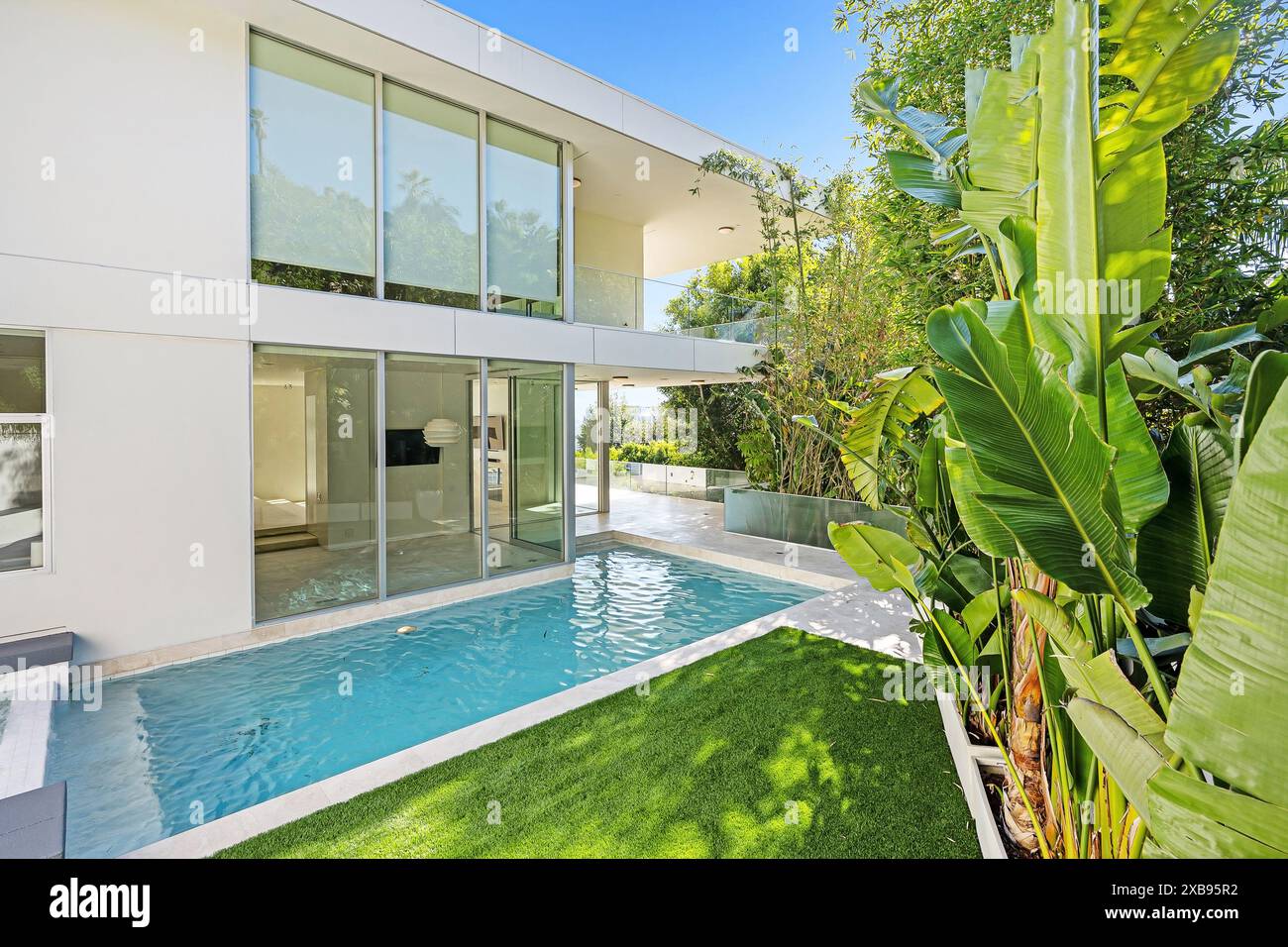 A Contemporary home with expansive front-facing glass windows beside a ...