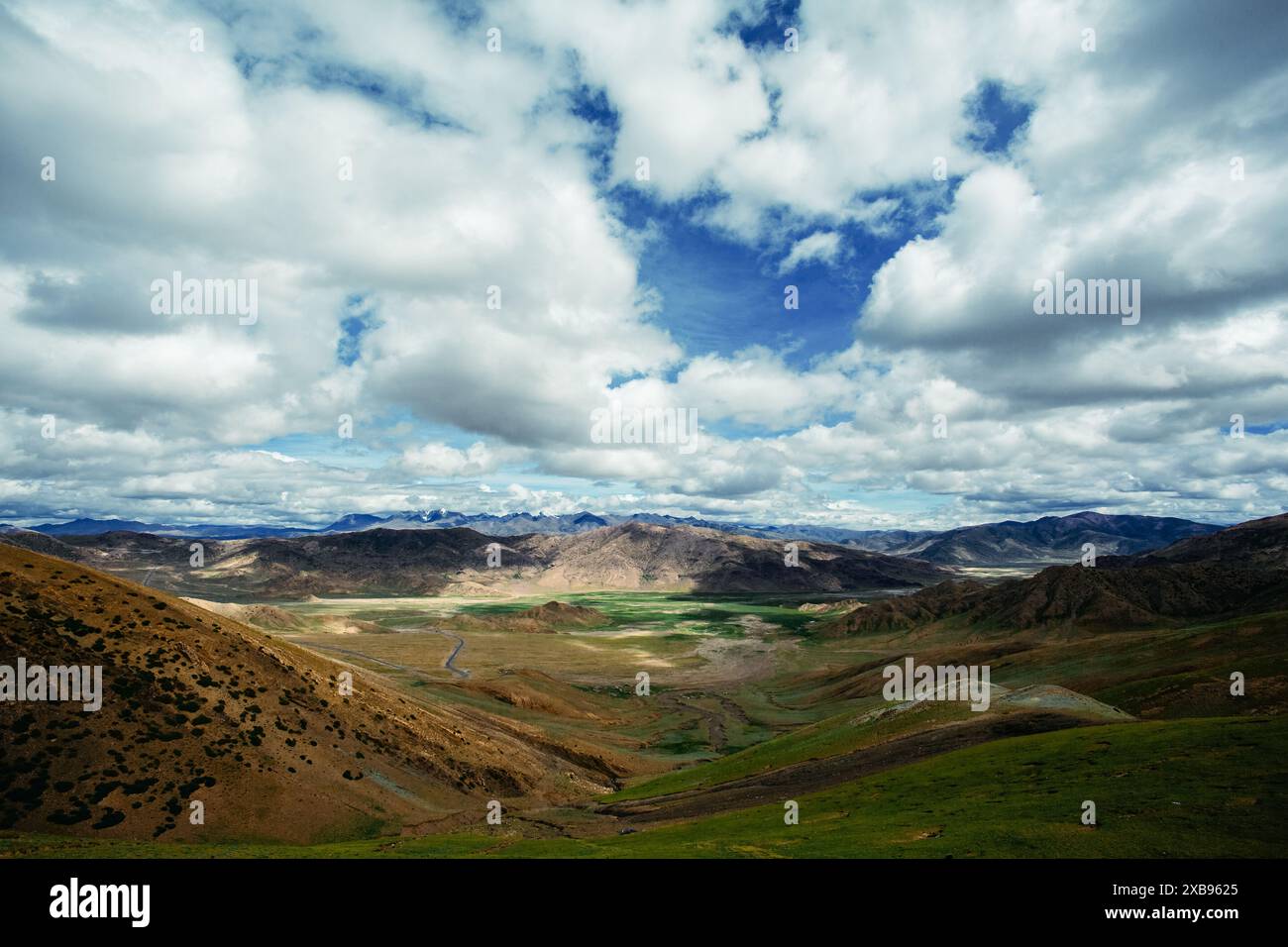 A stunning and vast mountain valley with rolling hills and distant ...
