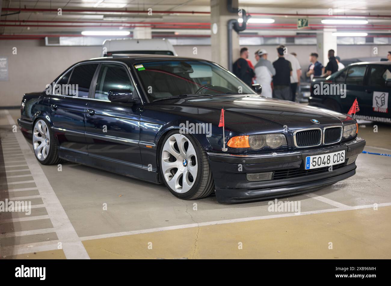 German car BMW E38 in dark color with the German imperial eagle flag on ...