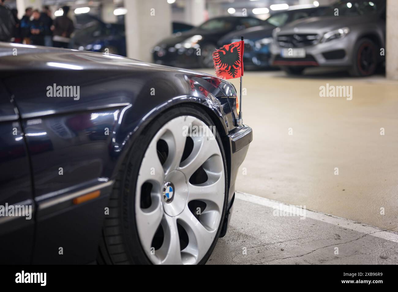 German car BMW E38 in dark color with the German imperial eagle flag on ...