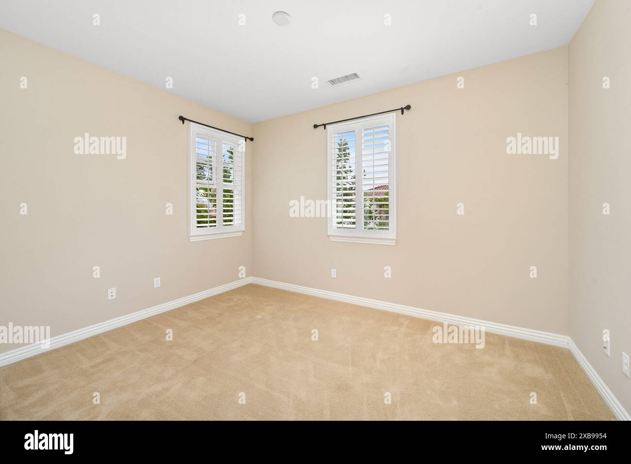 An empty room with two windows and tan walls. California, USA Stock ...