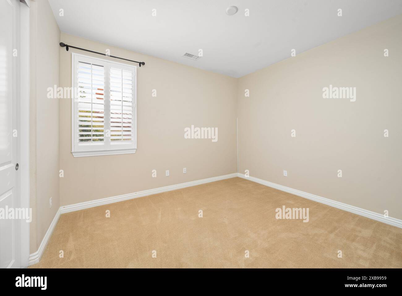 An empty room with tan walls and a window with blinds. California, USA ...
