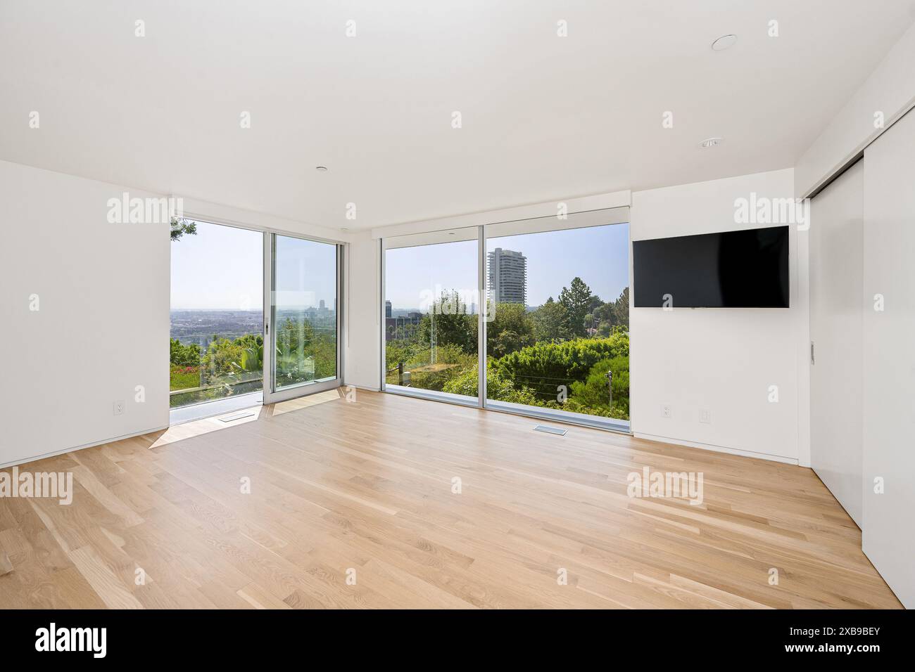 A room with white walls and a large window facing the street Stock ...
