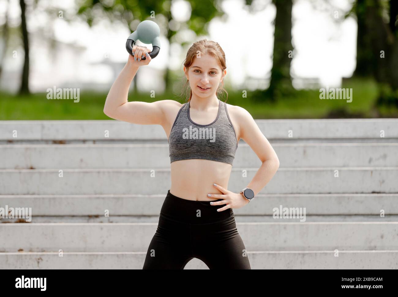 Teenage Girl Exercises With Kettlebell In Park During Summer Stock ...