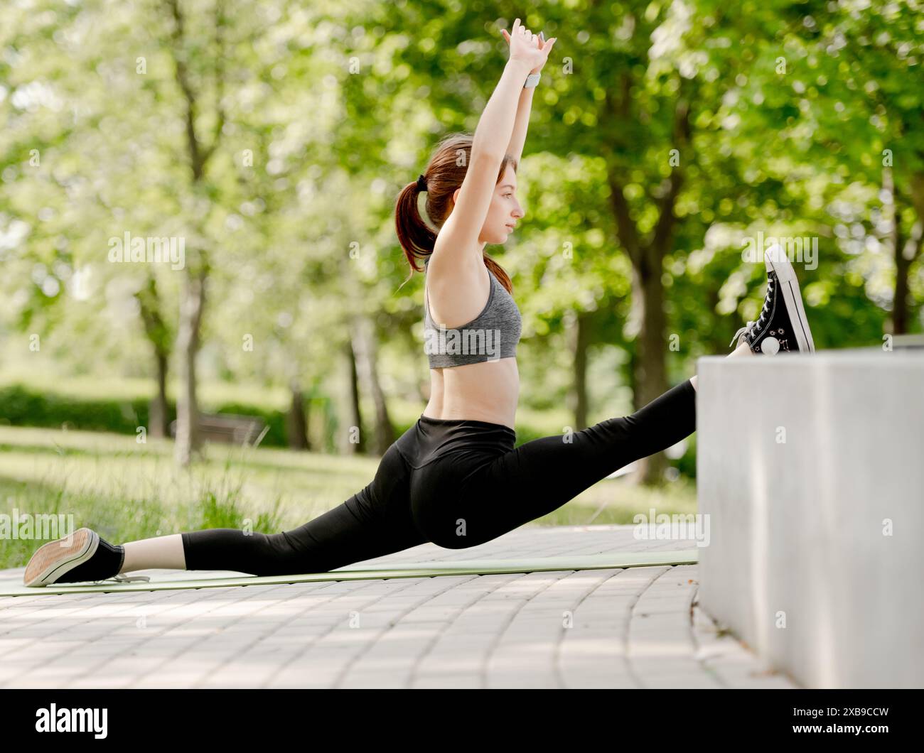 Girl Dancer Sits In Splits At Park For Warm-Up, View From Behind Stock ...