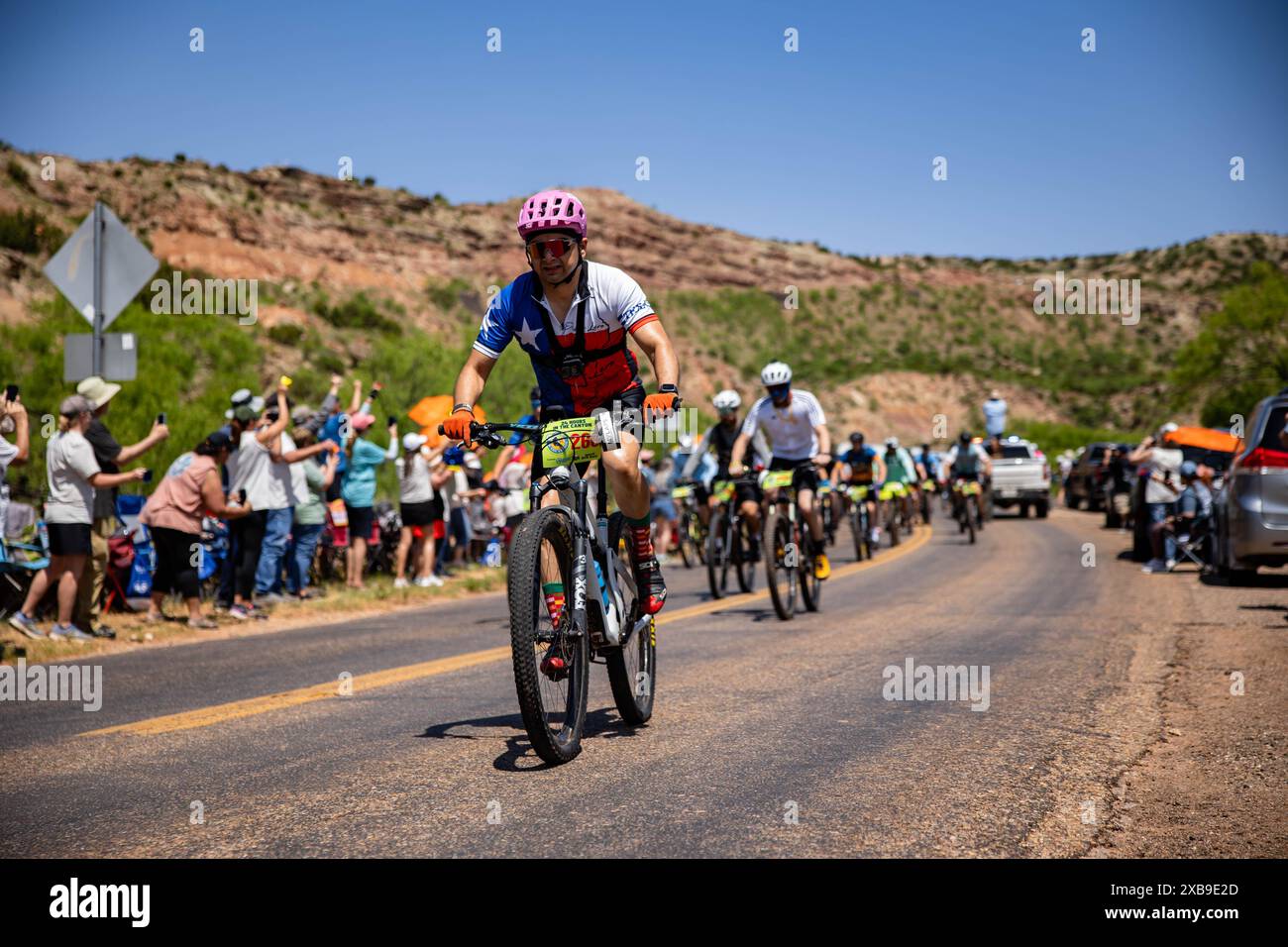 The cyclists participating in a mountain bike race with spectators ...