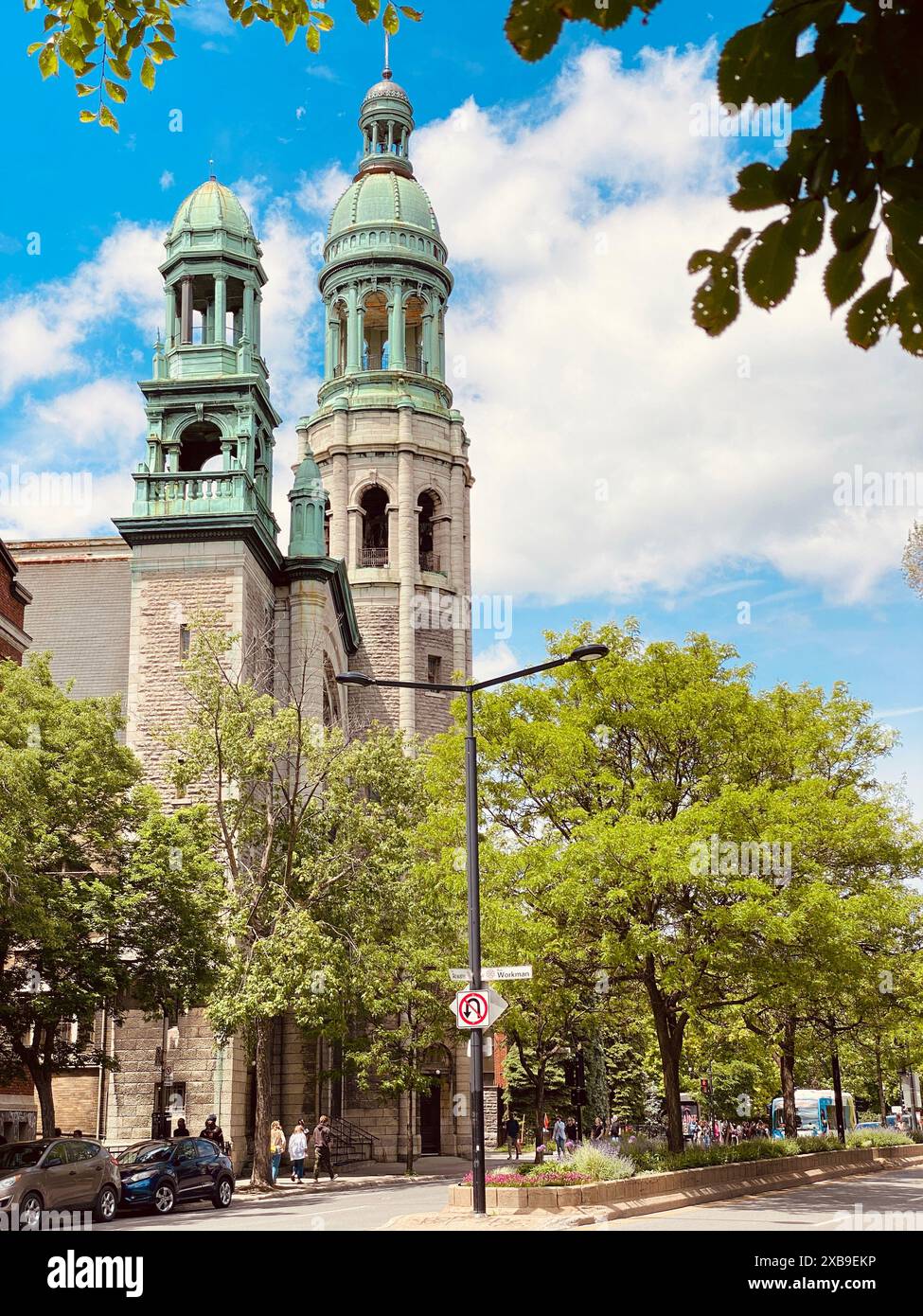 A tall building with a tower and surrounding greenery in Montreal ...