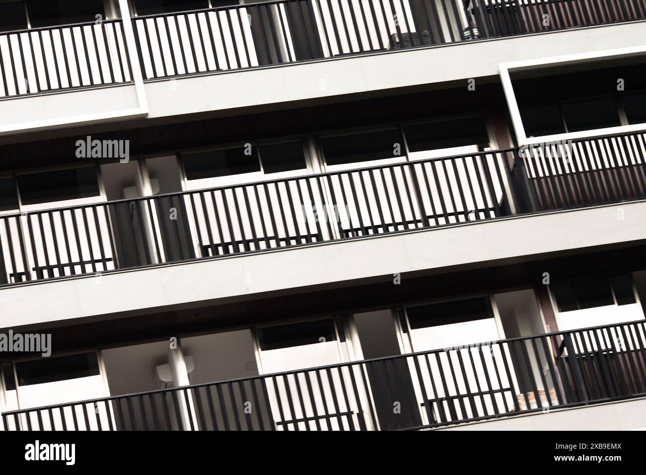 A modern apartment building with balconies and railings in a diagonal ...