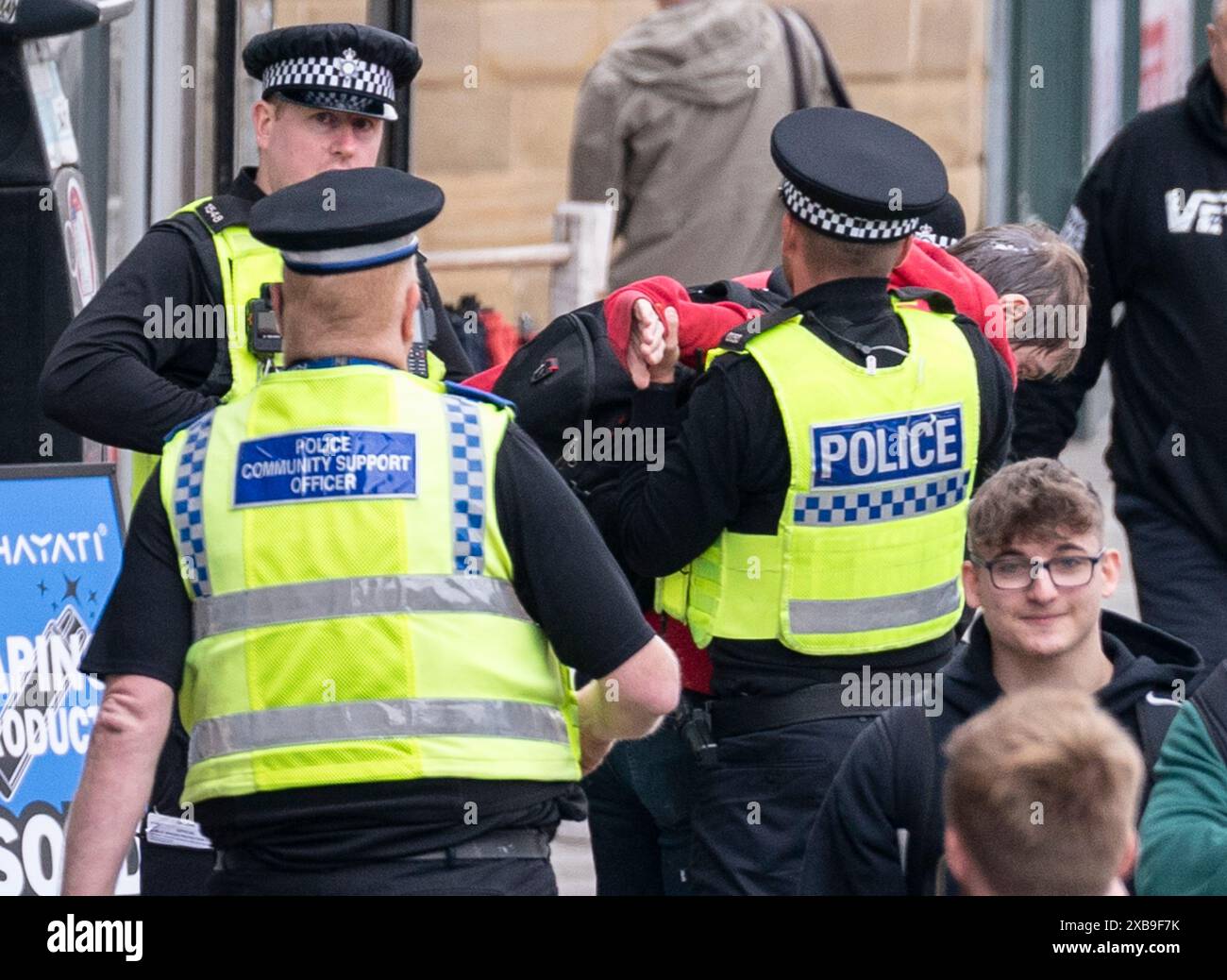 Police officers escort a person after he threw a cup towards Reform UK ...