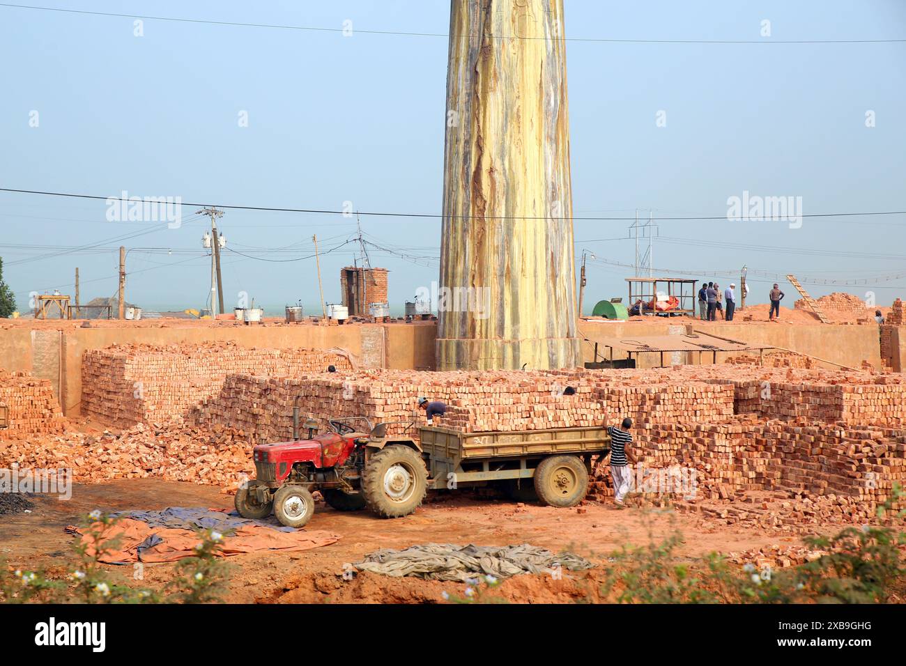 Soil mud bricks in an open field are left to dry in the sun before ...