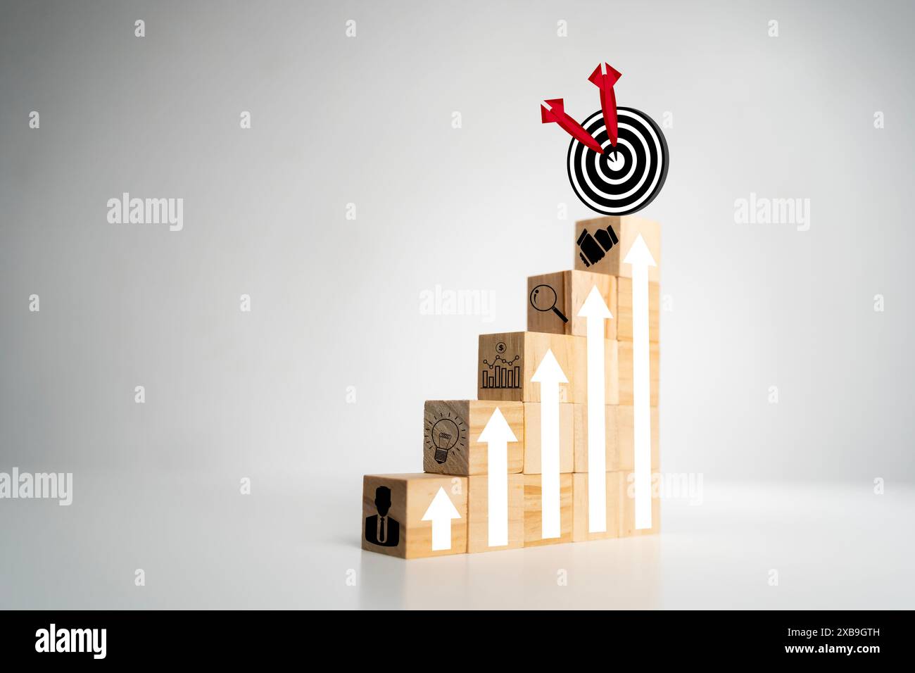 Woods block step on table with icon Action plan. target icon on the top ...