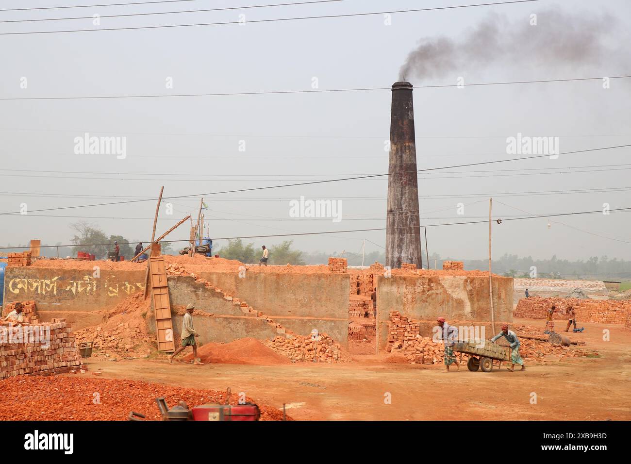 Soil mud bricks in an open field are left to dry in the sun before ...