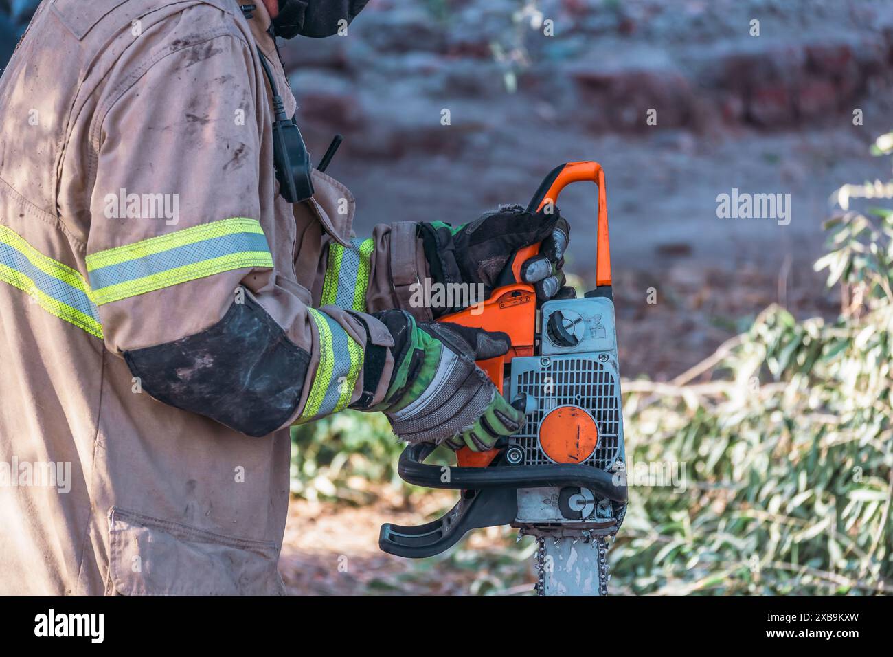 Firefighter starting chainsaw, in rescue Stock Photo - Alamy