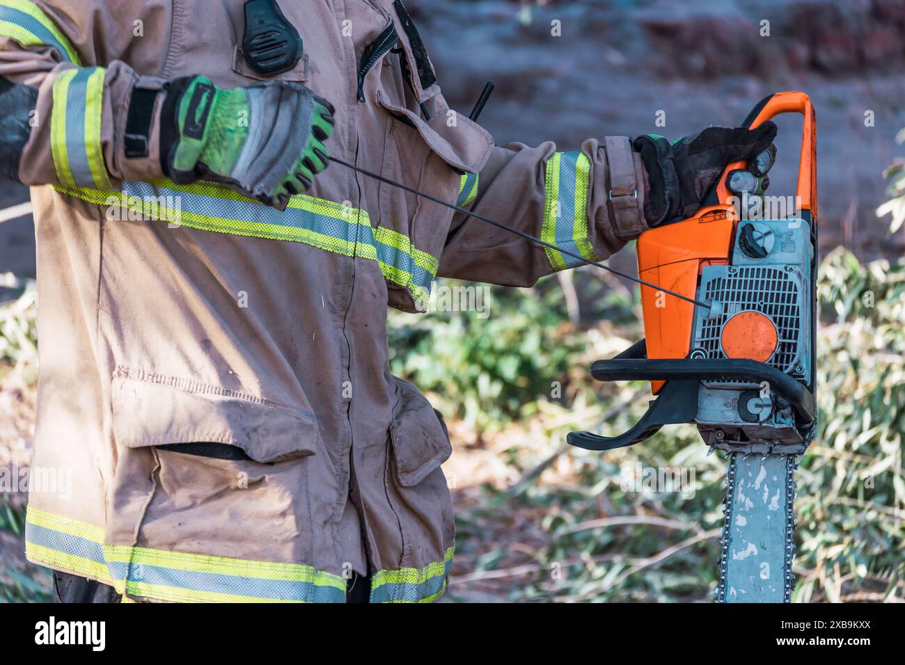 Firefighter starting chainsaw, in rescue Stock Photo - Alamy