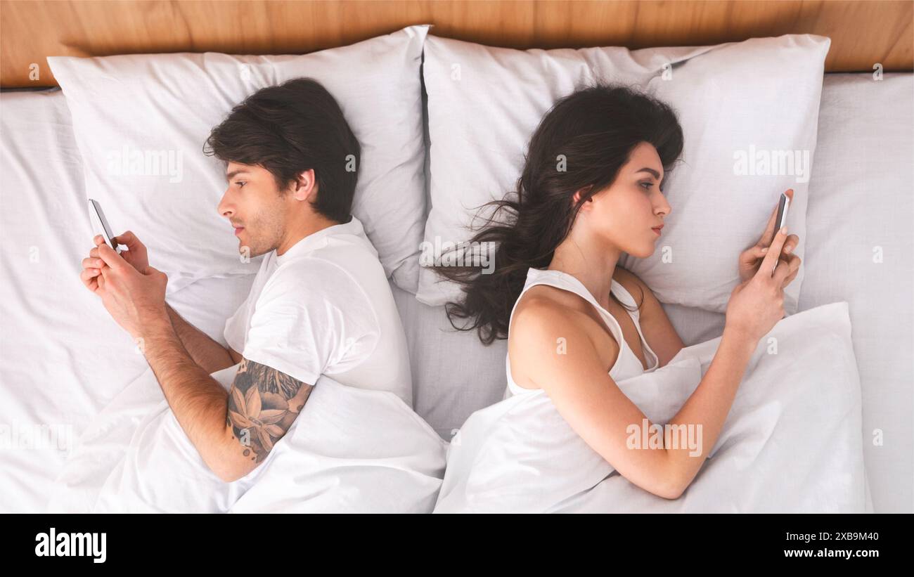 Couple Using Smartphones In Bed At Night Stock Photo - Alamy