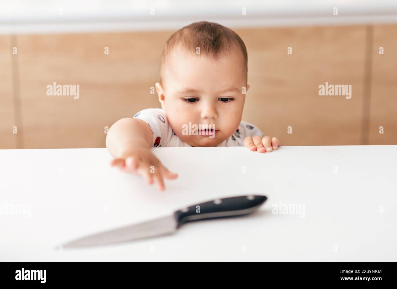 Curious Baby Boy Reaching For Knife on Kitchen Counter Stock Photo - Alamy
