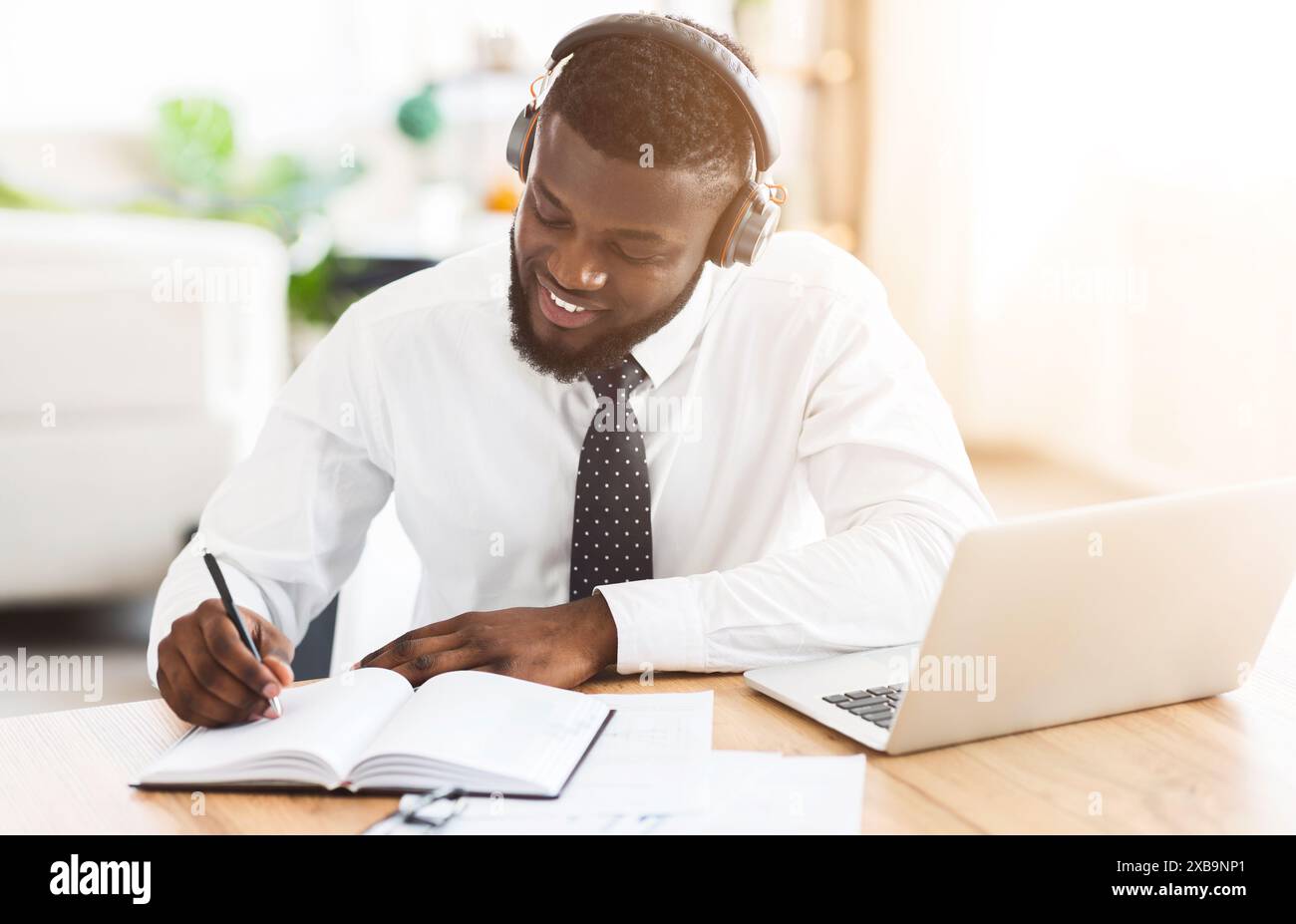 Creative businessman listening to music at workplace, planning future ...
