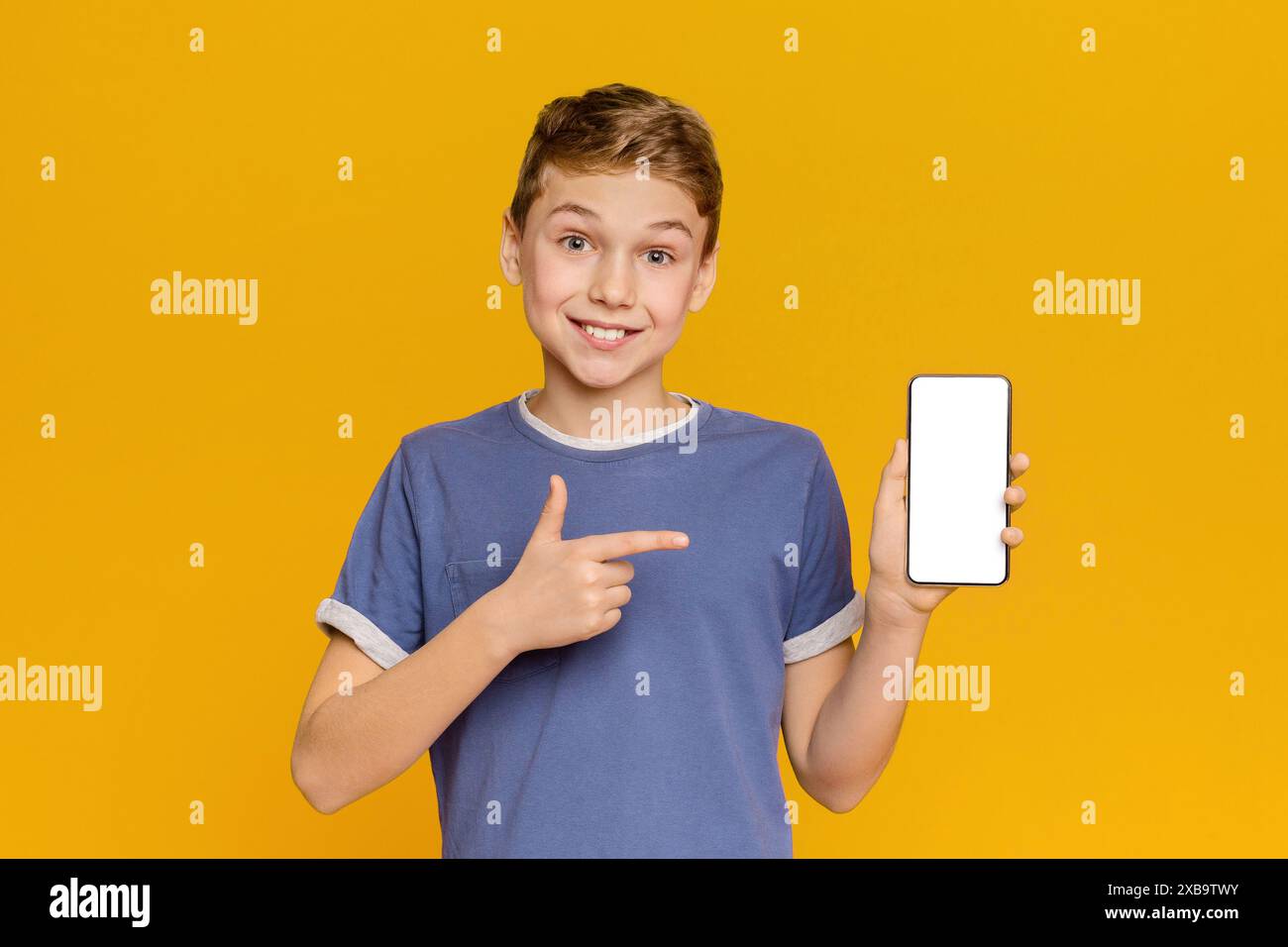 Emotional teen boy pointing at white mobile screen and smiling Stock ...