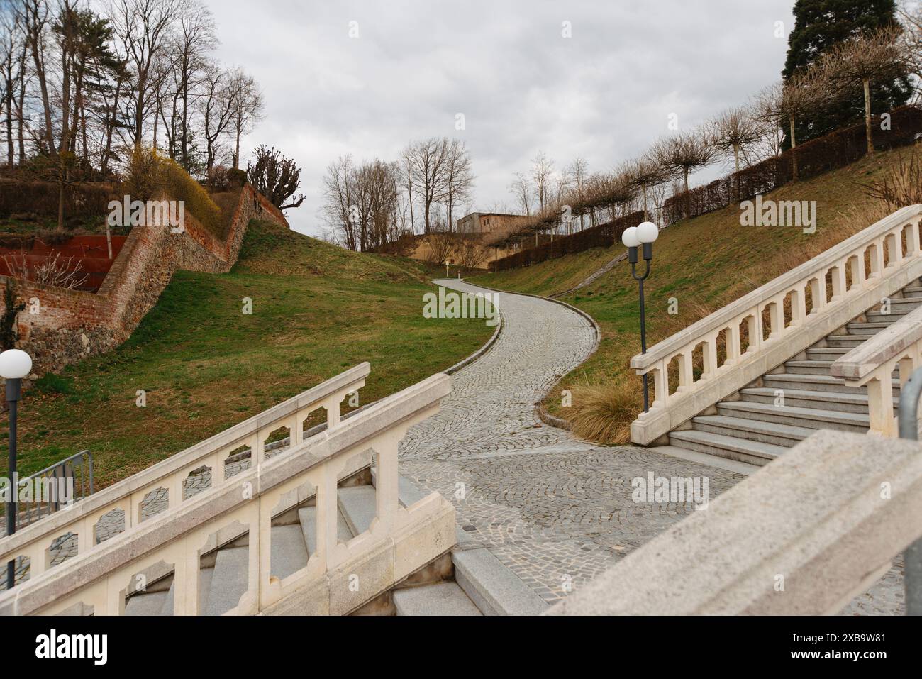A winding pathway cuts through landscaped hills with stone stairs under ...