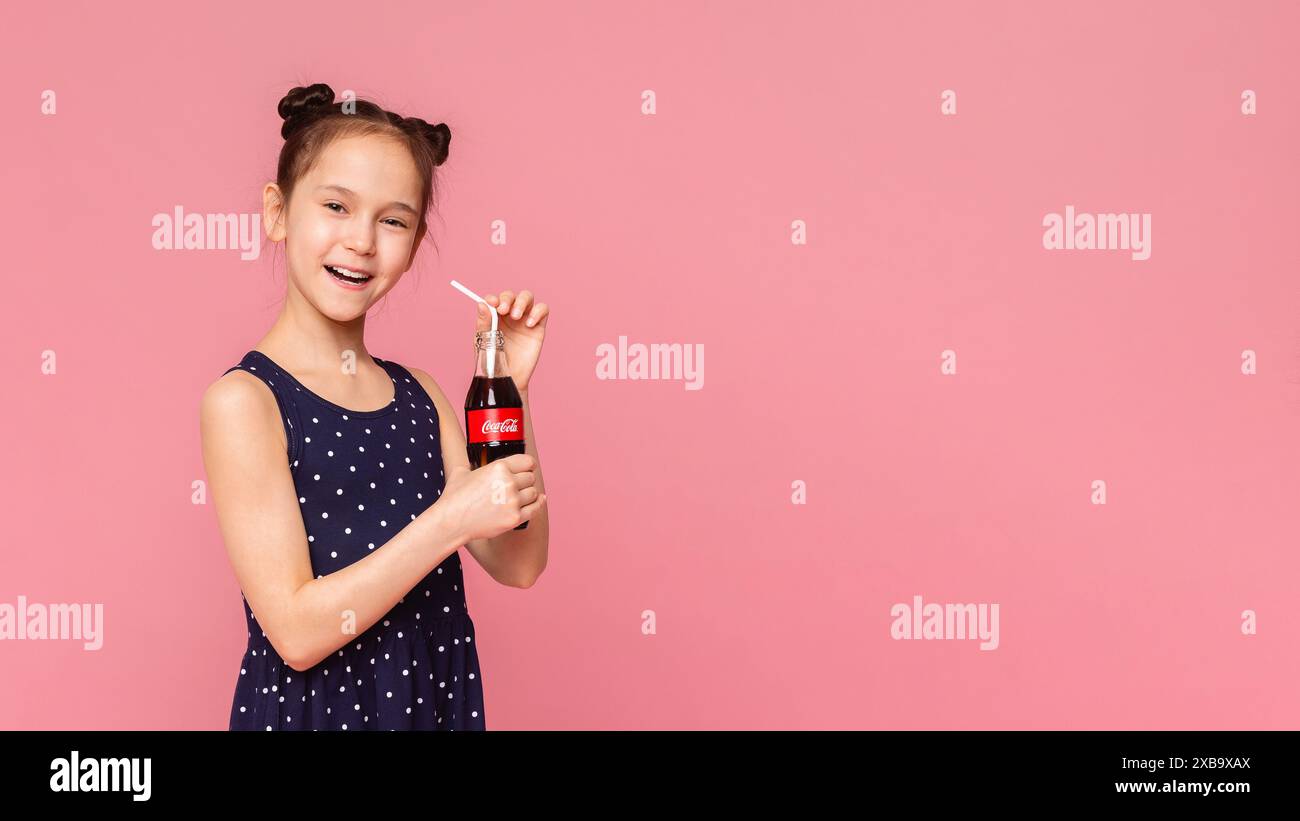 Little girl drinking Coca-Cola Classic with straw on pink background ...