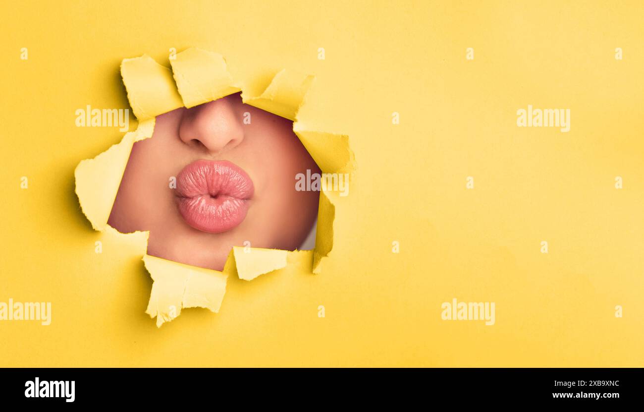 Woman Lips Peeking Out Of Hole In Yellow Paper Stock Photo - Alamy