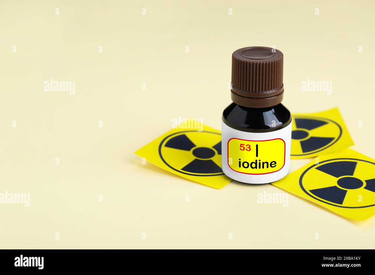 Bottle of medical iodine and radiation signs on beige background. Space ...