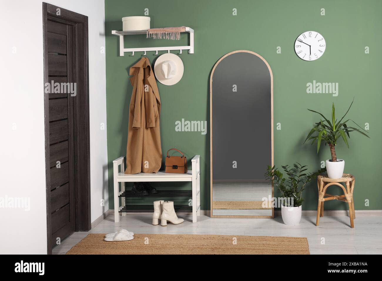 Stylish hallway with shoe storage bench and mirror near sage green wall ...