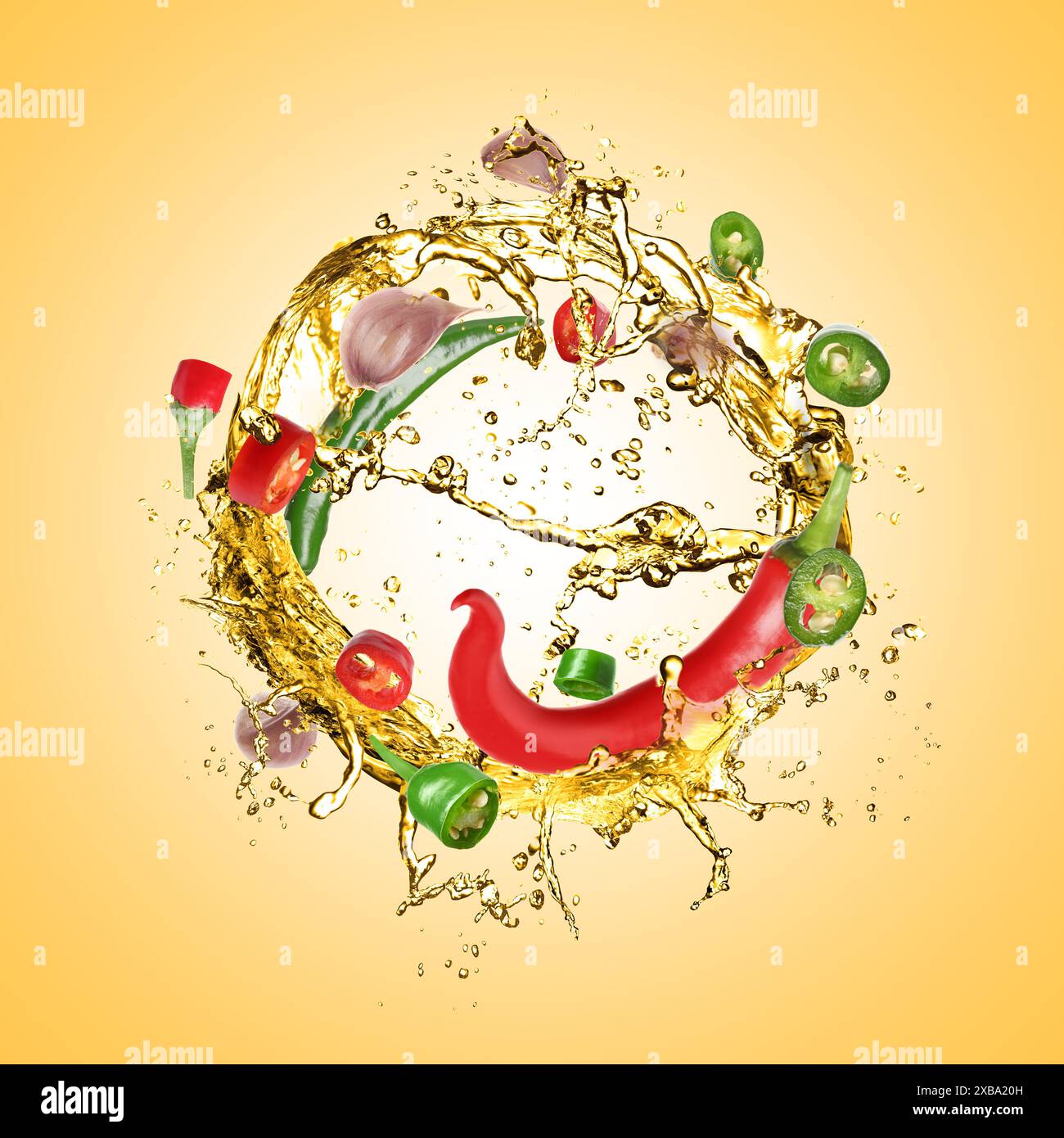 Cooking oil splash with chili peppers and garlic in air on golden ...