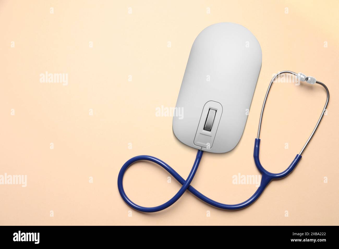 Computer mouse with stethoscope on beige background, top view. Online ...