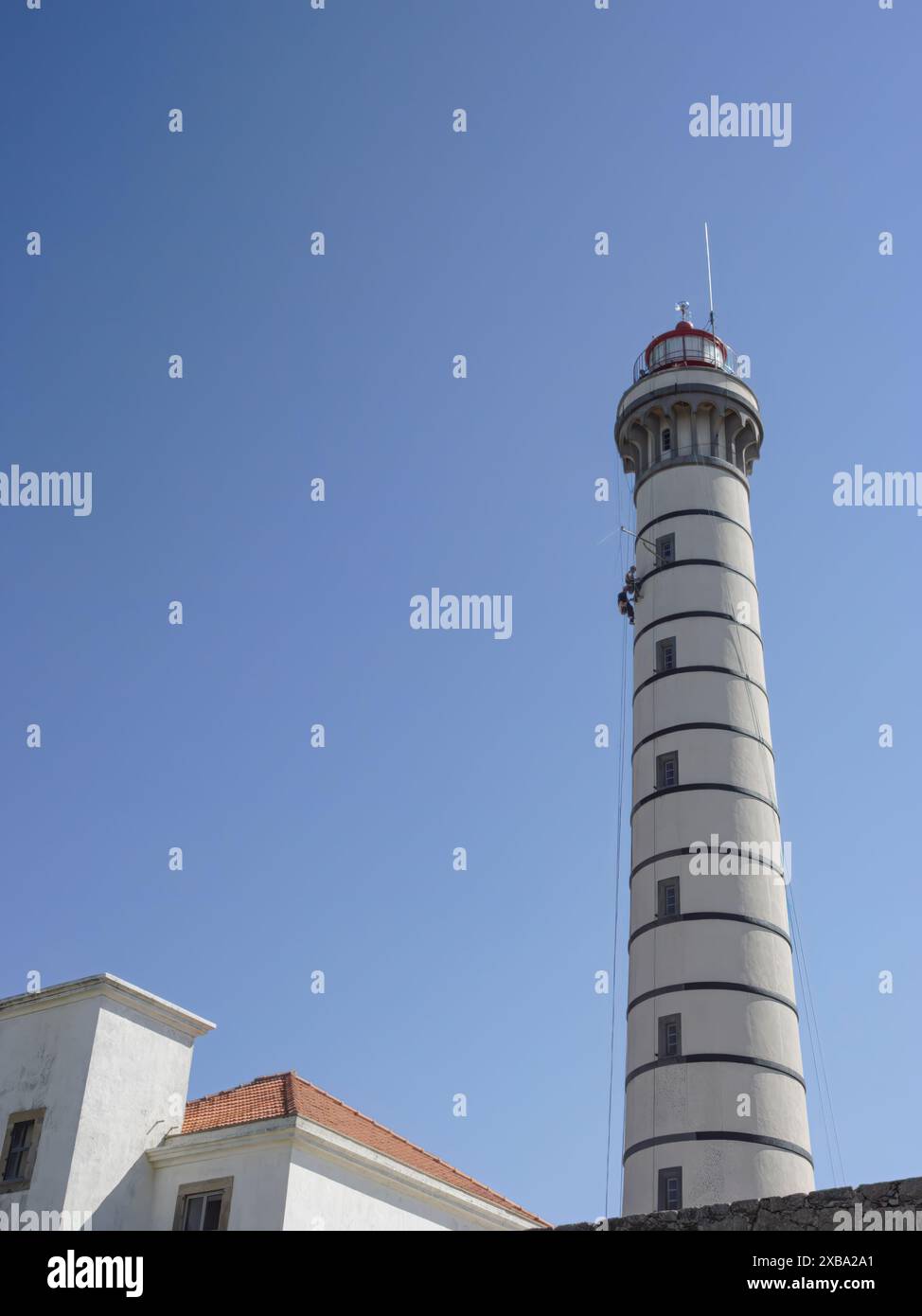 Professional climbers working in the maintenance of a high lighthouse ...