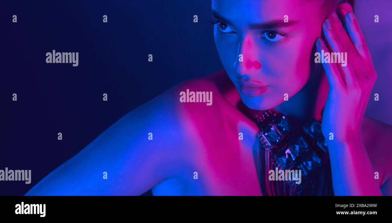Woman in Neon Blue and Pink Lighting Touching Her Face Stock Photo - Alamy