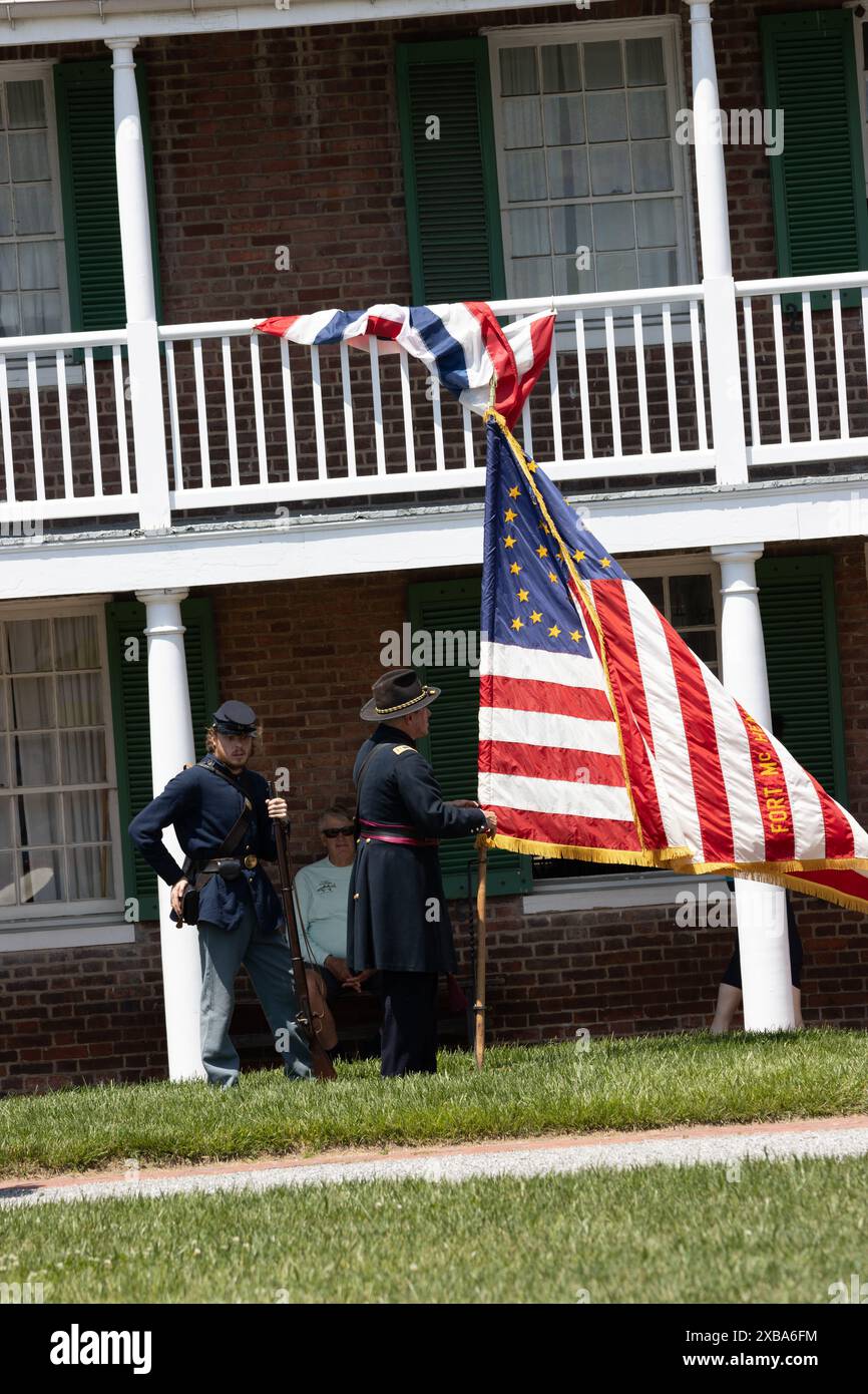 The reenactors in military uniforms holding a vintage American flag in ...