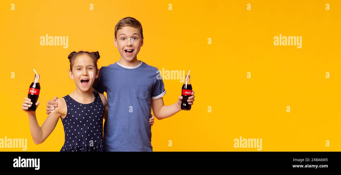 Happy children drinking Coca-Cola Classic with straws on orange Stock ...