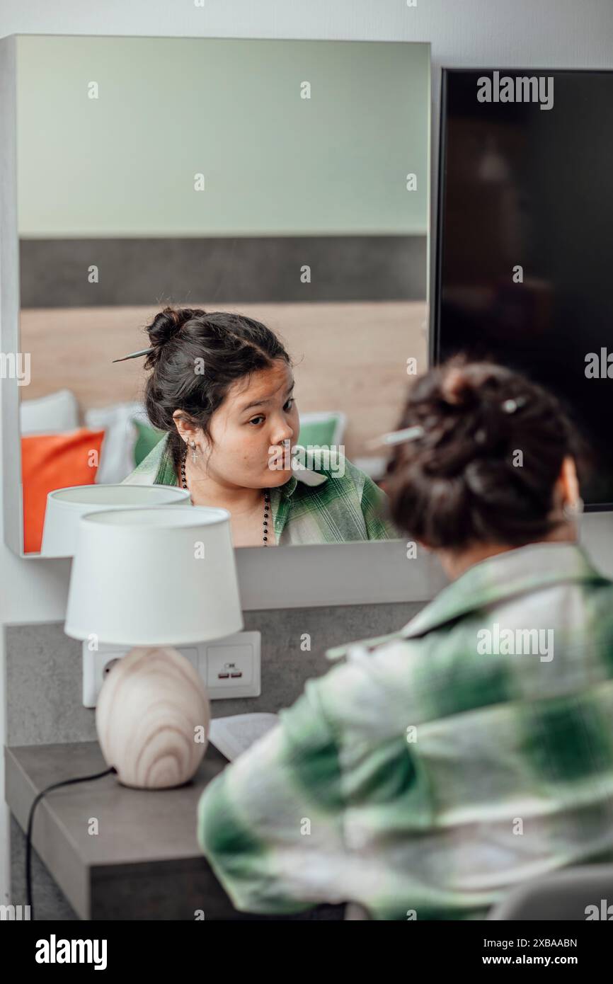 asian girl s expression in the mirror suggests a silent conversation ...