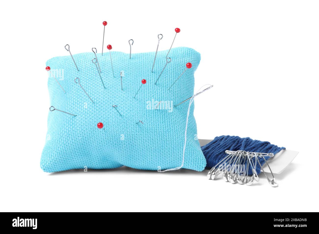 Light blue pincushion with sewing pins and threads isolated on white ...