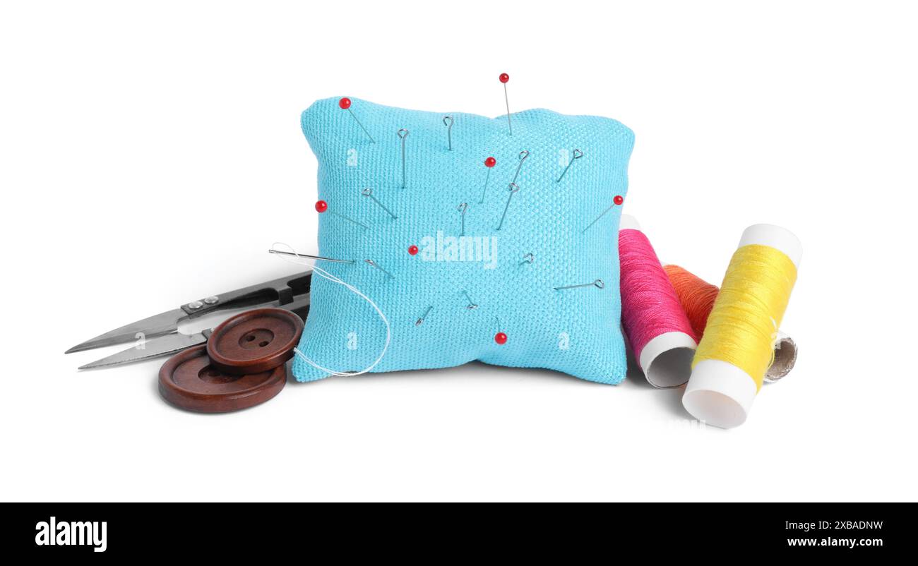 Light blue pincushion with sewing pins, spools of threads, cutter and ...