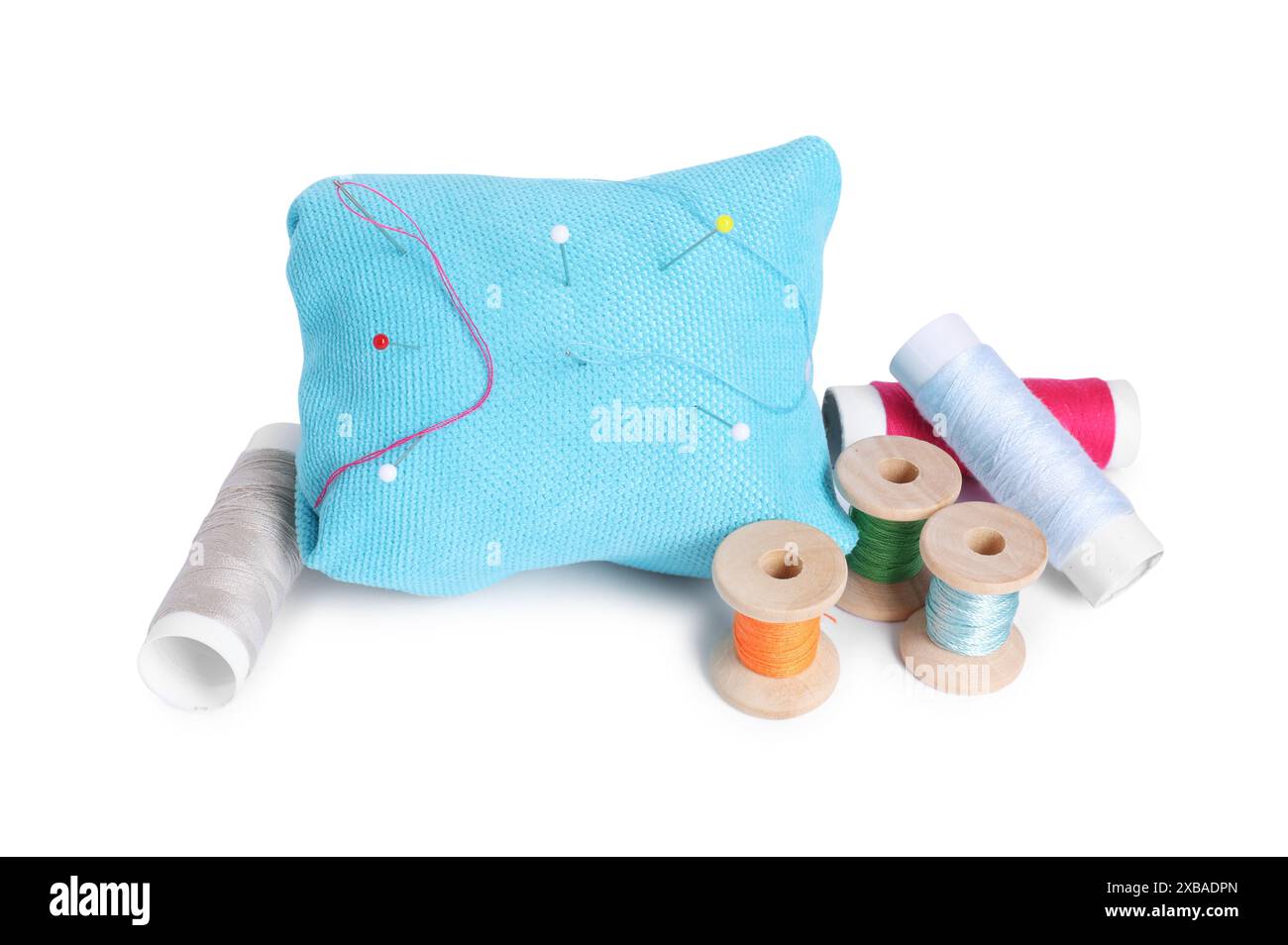 Pincushion, sewing pins, needle and spools of threads isolated on white ...