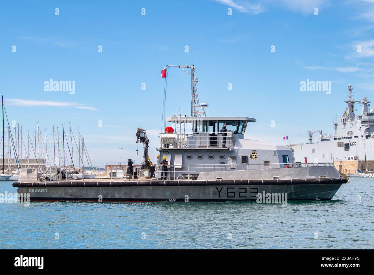 The hybrid-powered military barge “Criquet” waits to collect waste as ...