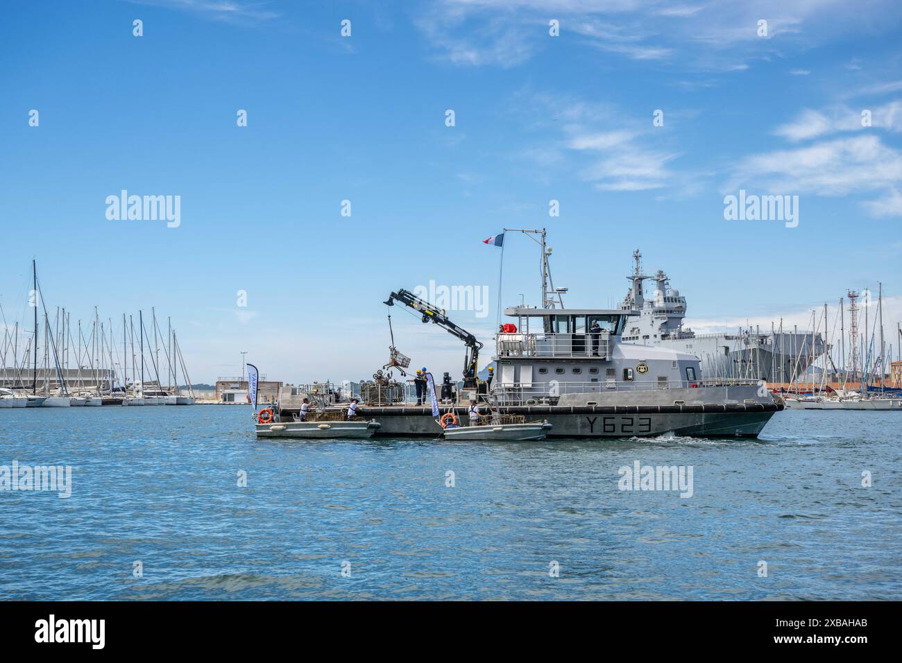 Recovered waste is hoisted onto a hybrid-powered military barge as part ...