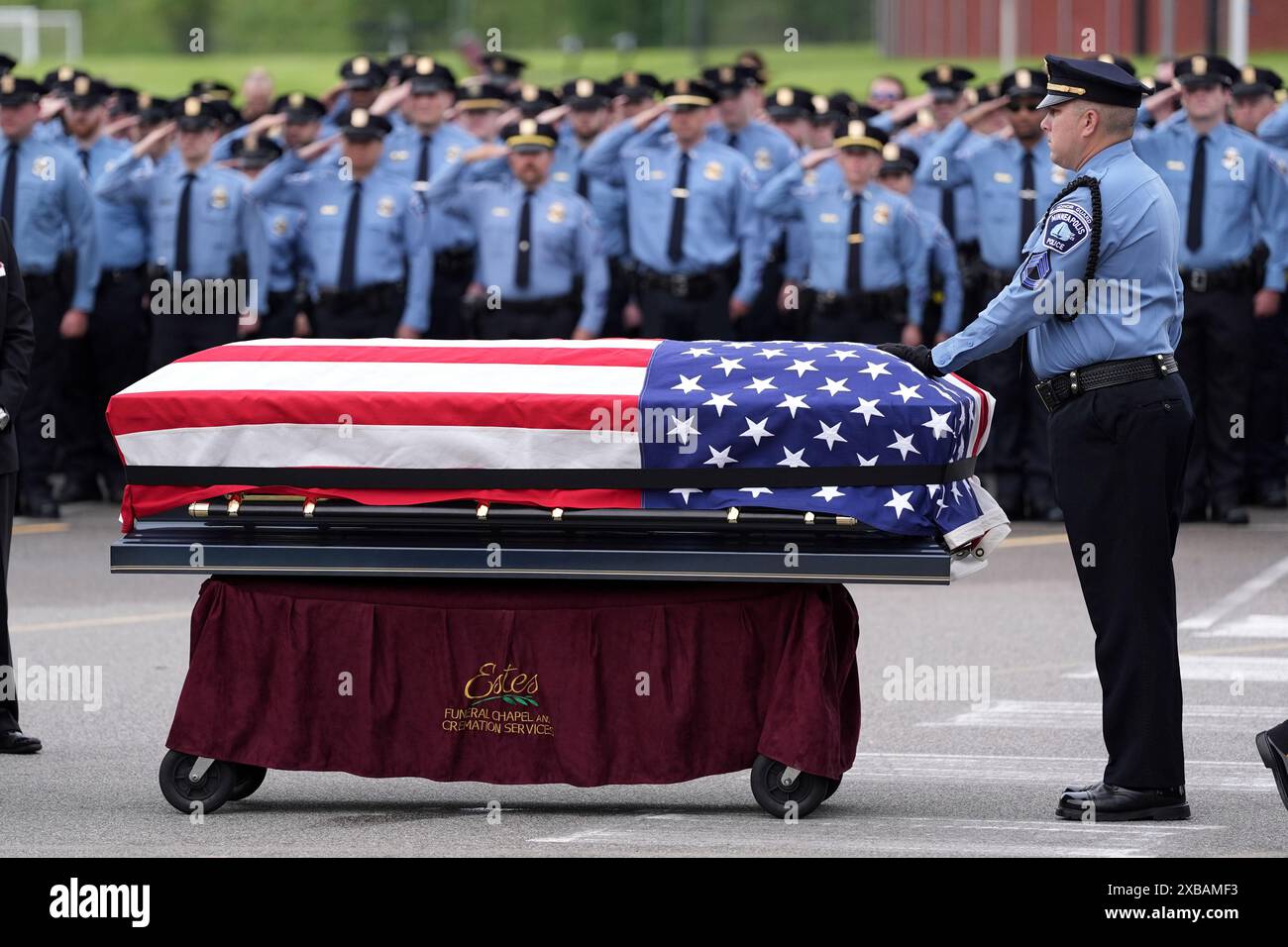 A Minneapolis Police Department honor guard member places a hand on the ...